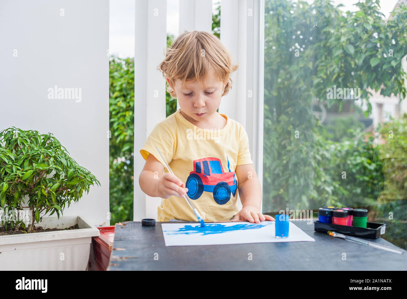 Cute little boy painting with colorful paints Stock Photo - Alamy