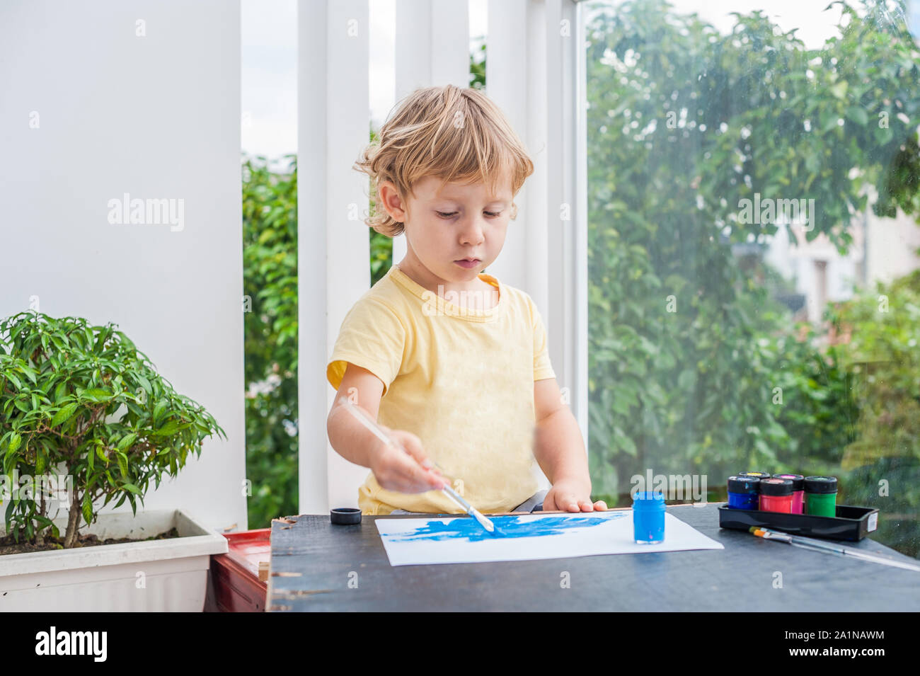 Cute little boy painting with colorful paints Stock Photo - Alamy