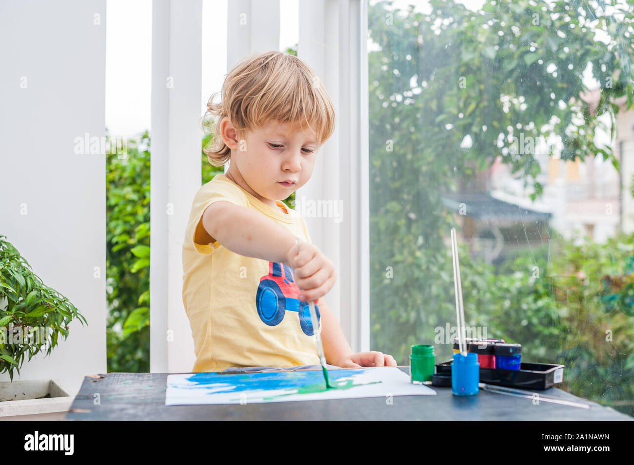 Cute little boy painting with colorful paints Stock Photo - Alamy
