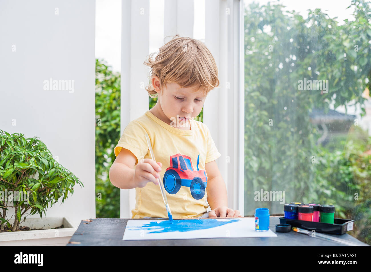Cute little boy painting with colorful paints Stock Photo - Alamy
