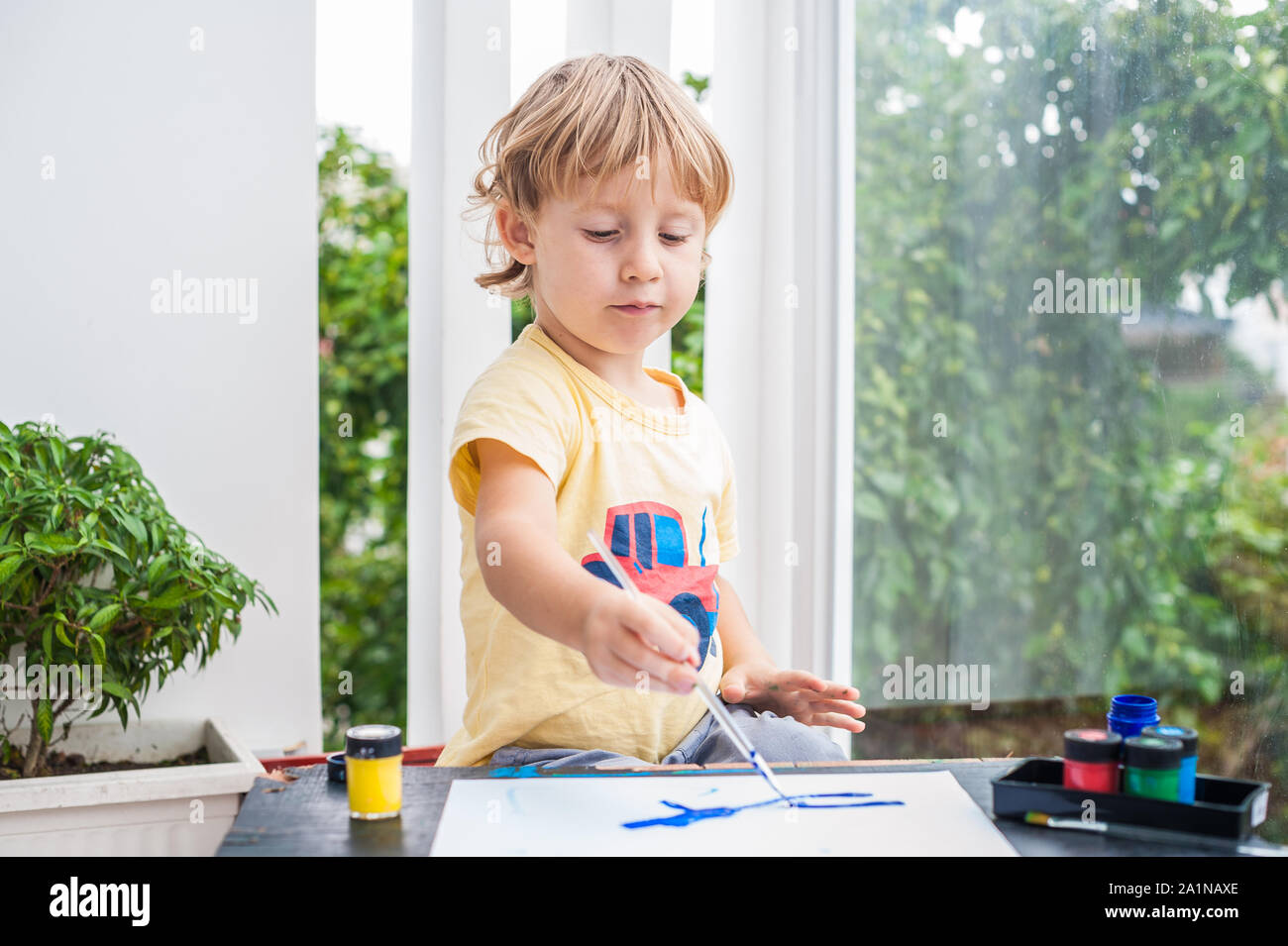 Cute little boy painting with colorful paints Stock Photo - Alamy