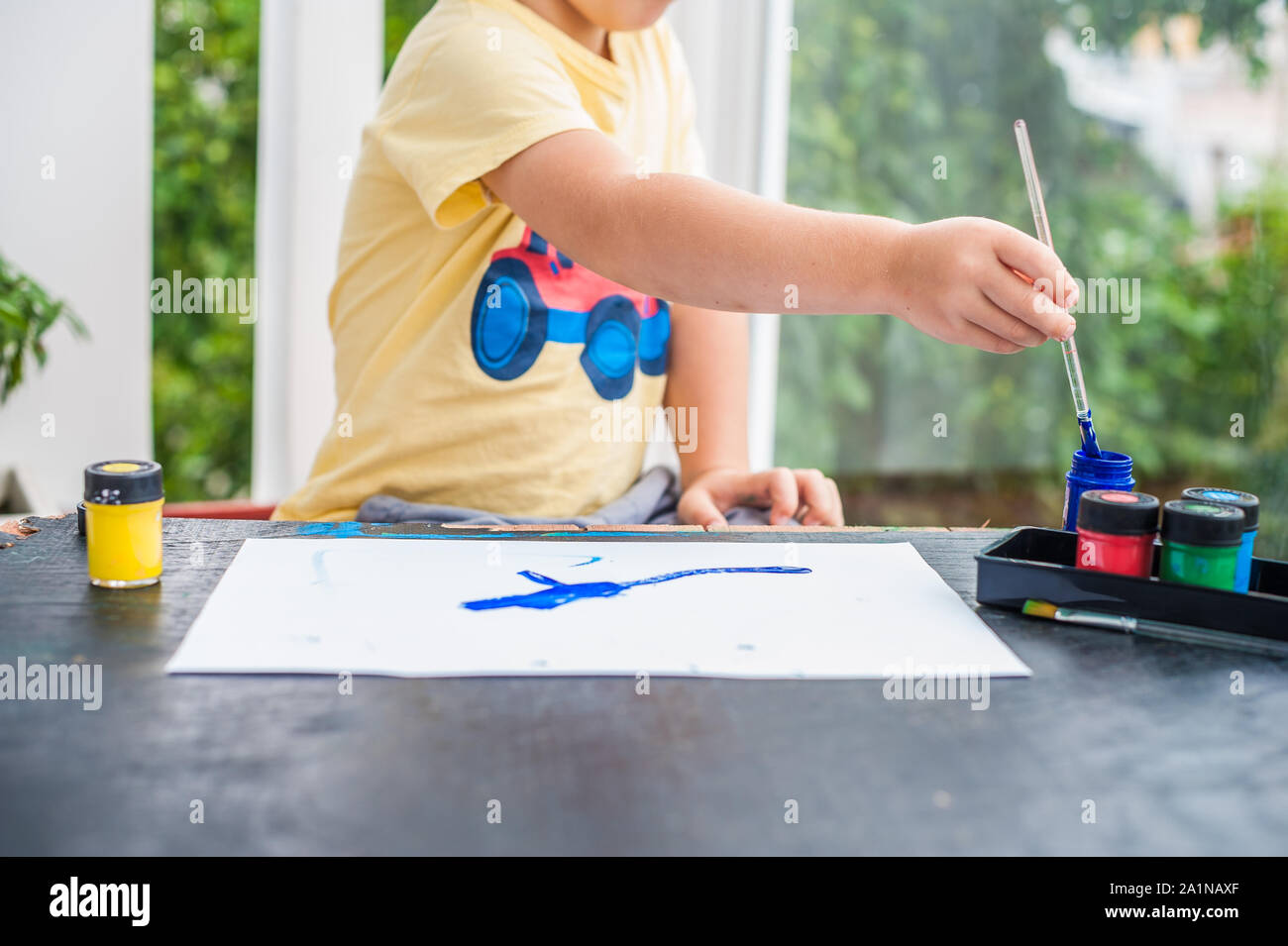 Cute little boy painting with colorful paints Stock Photo - Alamy