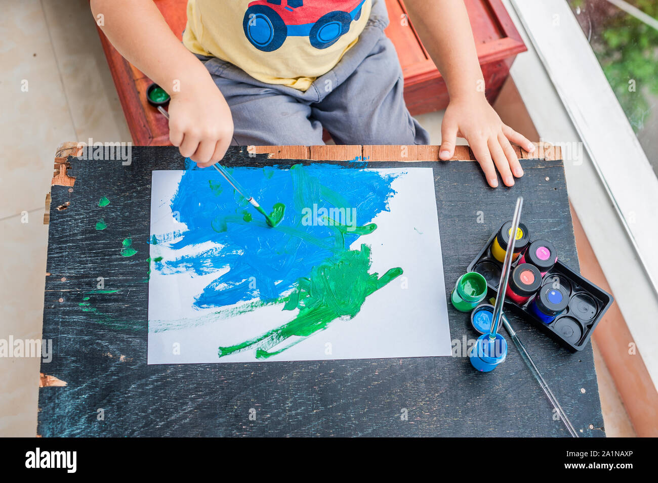 Cute little boy painting with colorful paints Stock Photo - Alamy