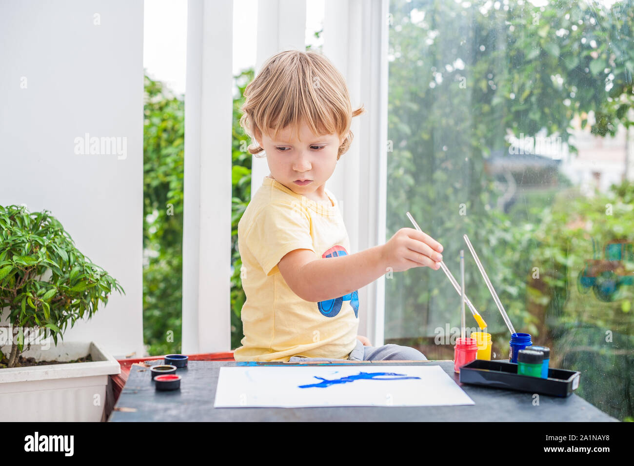 Cute little boy painting with colorful paints Stock Photo - Alamy