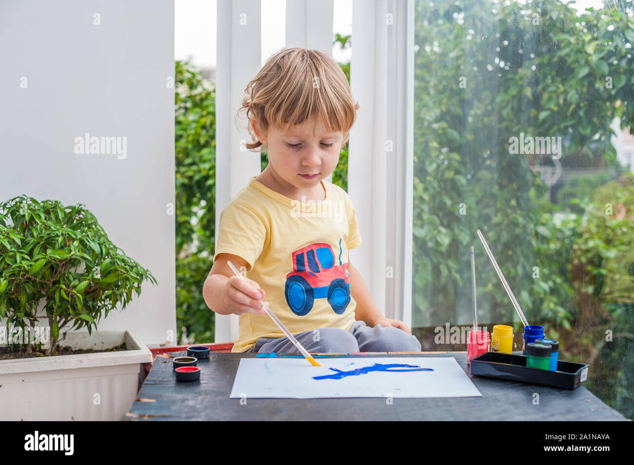Cute little boy painting with colorful paints Stock Photo - Alamy