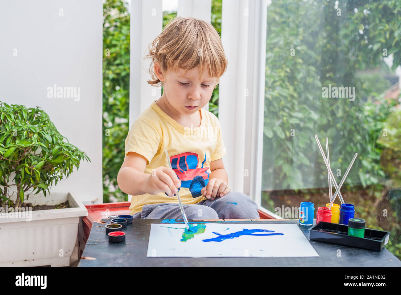 Cute little boy painting with colorful paints Stock Photo - Alamy