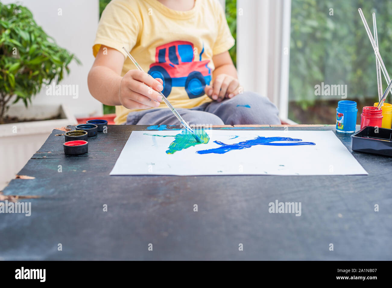 Cute little boy painting with colorful paints Stock Photo - Alamy