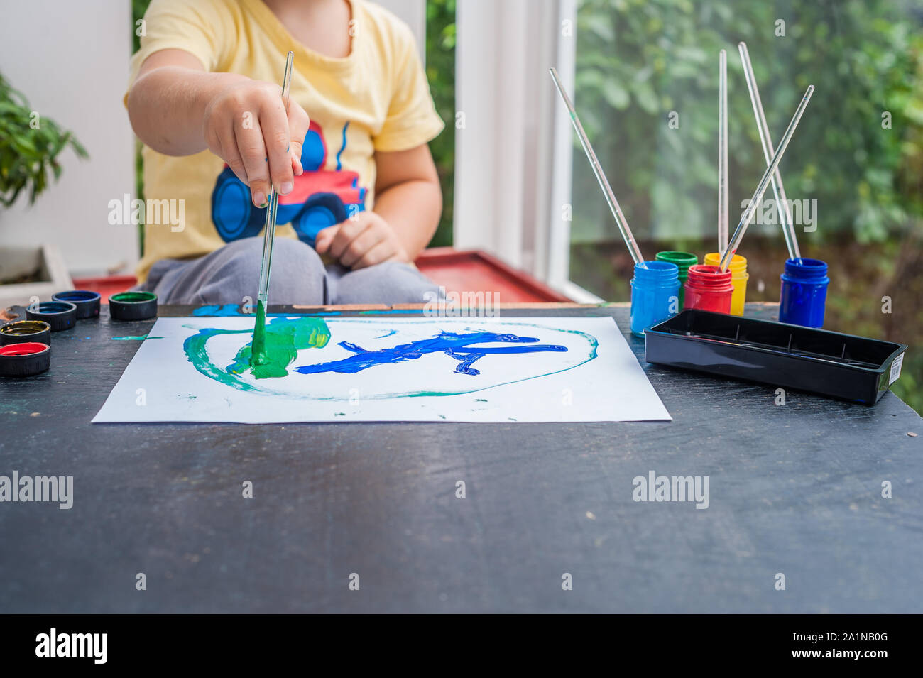 Cute little boy painting with colorful paints Stock Photo - Alamy
