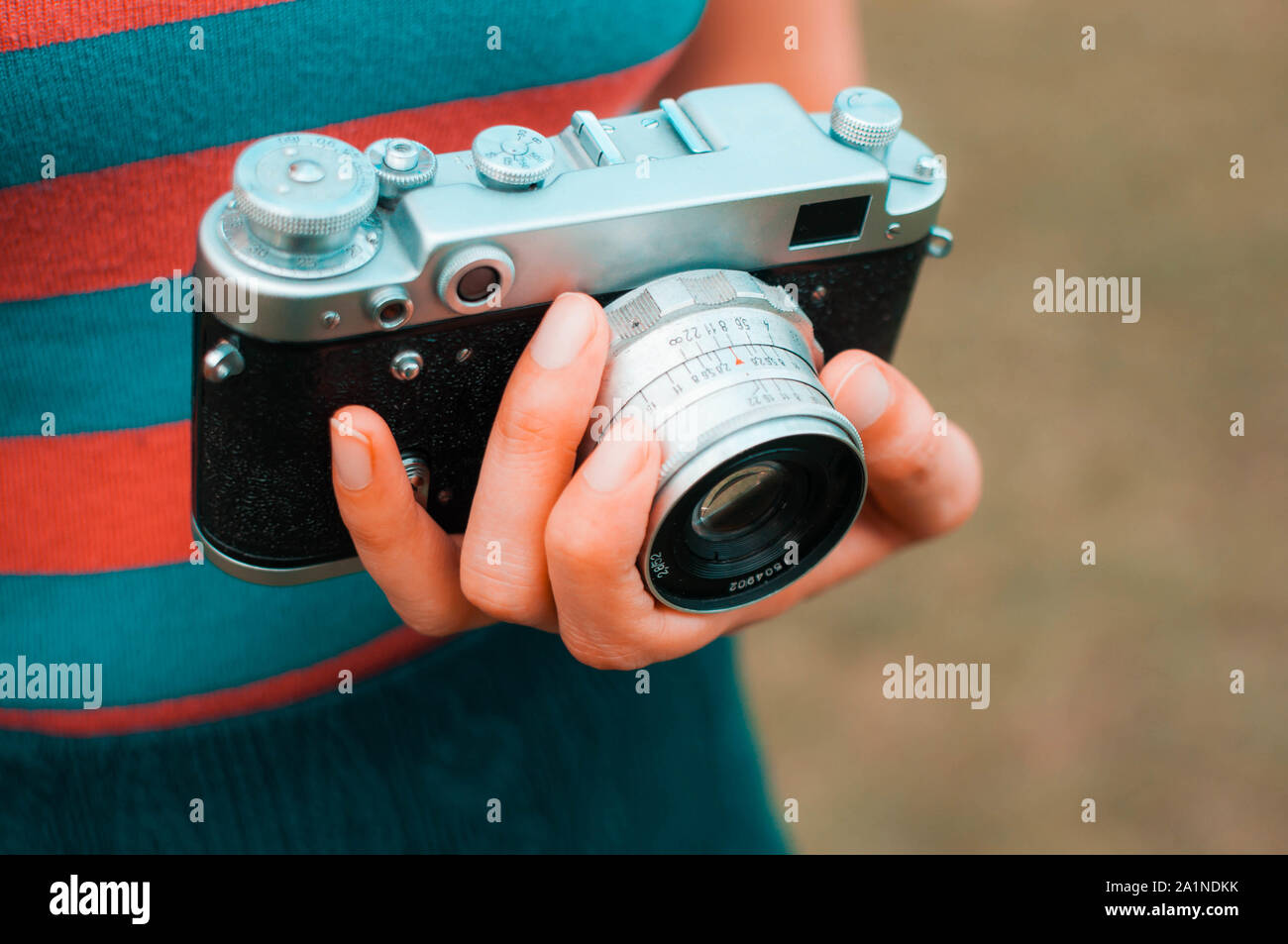 A young woman is carrying a vintage camera outdoor Stock Photo - Alamy