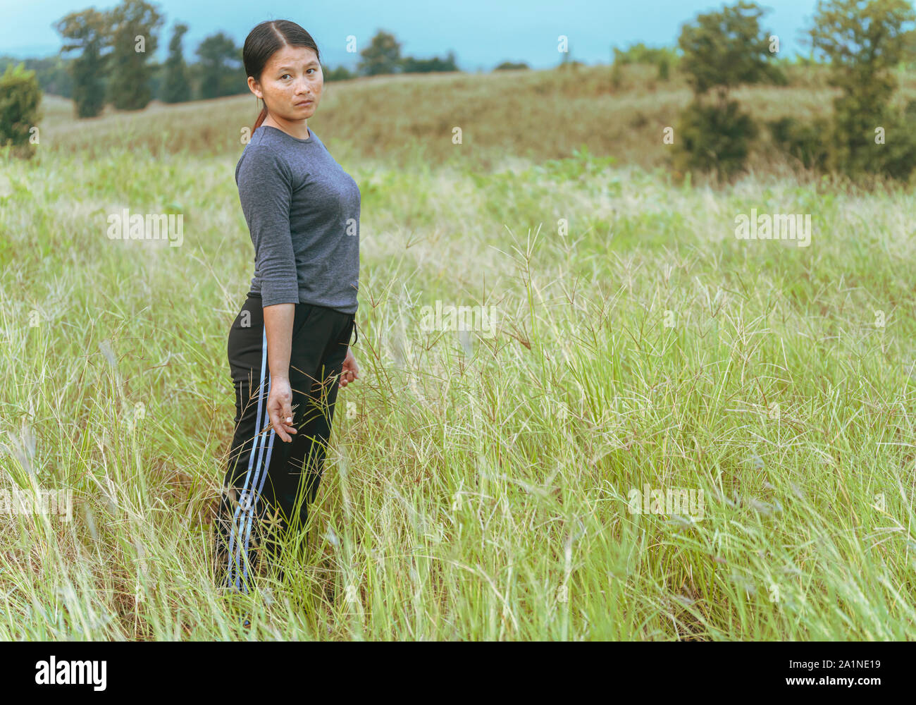 Beautiful asia woman standing at beautiful field grass Stock Photo - Alamy