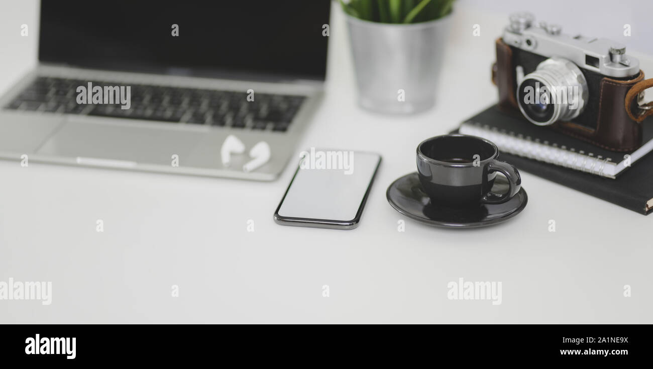 Modern photographer workplace with laptop computer, smartphone and ...