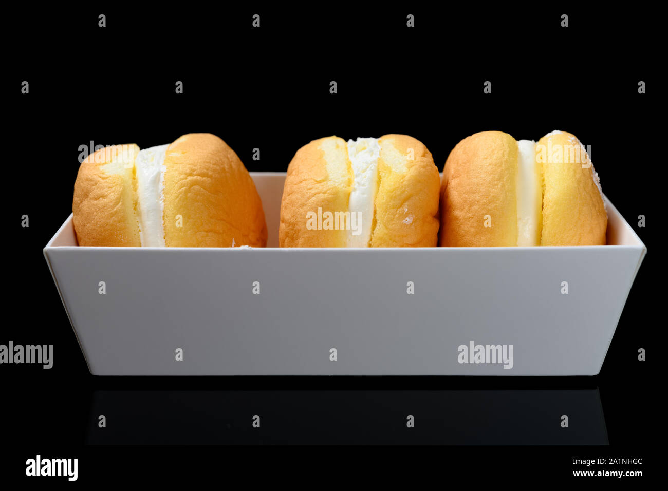 box of cakes with cream filling on black background Stock Photo - Alamy
