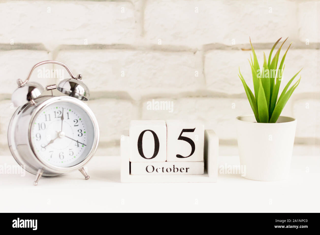 the fifth of October on the wooden calendar next to the alarm clock ...