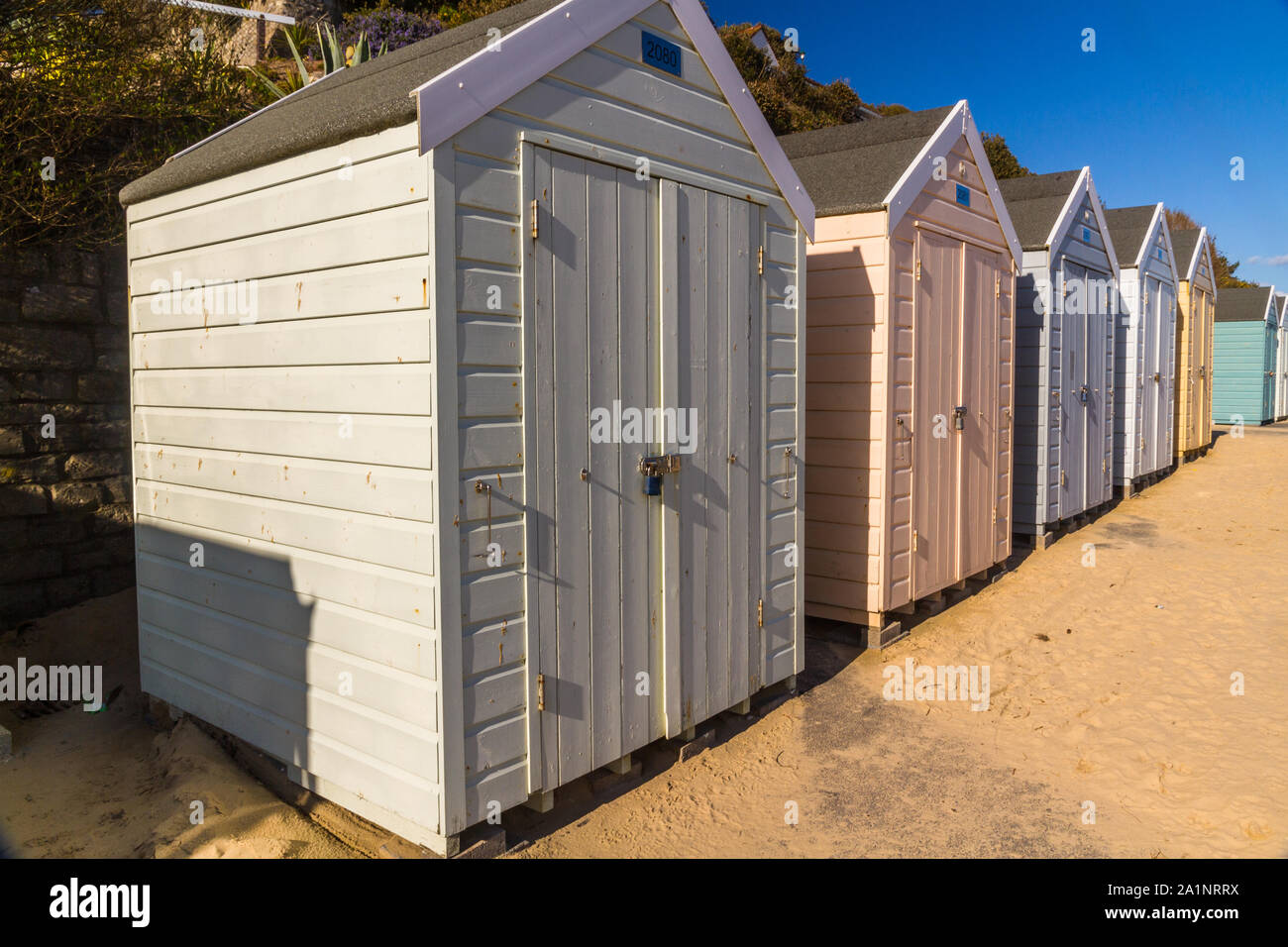Row of UK beach huts in low sunlight, landscape Stock Photo - Alamy