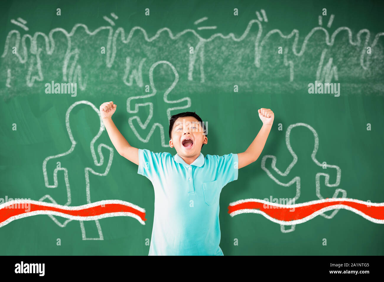 happy boy standing against chalkboard and showing the winner concepts ...