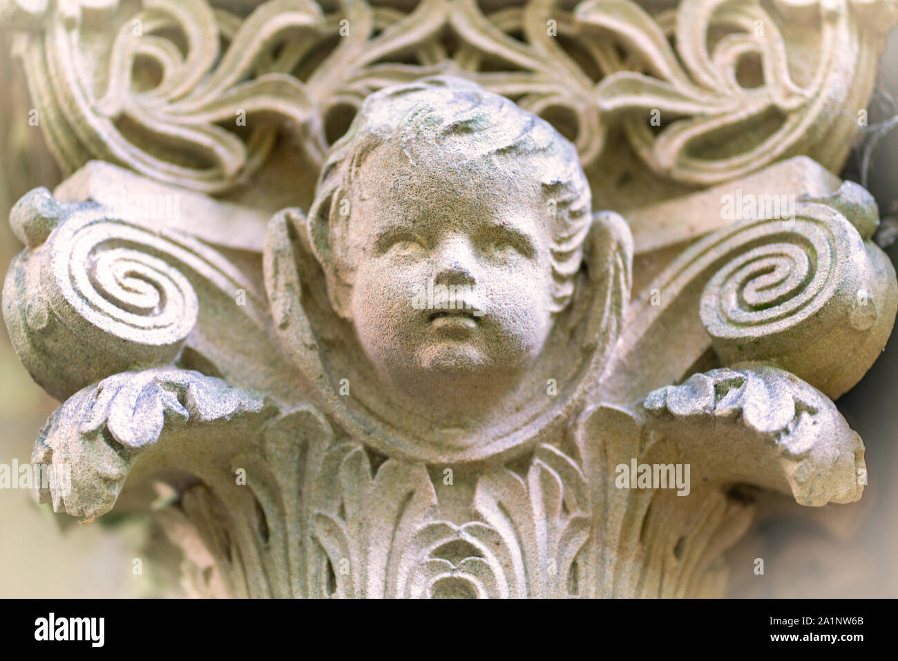 Detail of a tomb column on a graveyard- sculptured head of a little boy ...