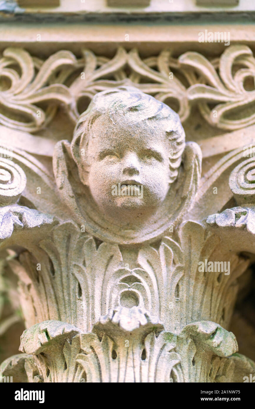 Detail of a tomb column on a graveyard- sculptured head of a little boy ...