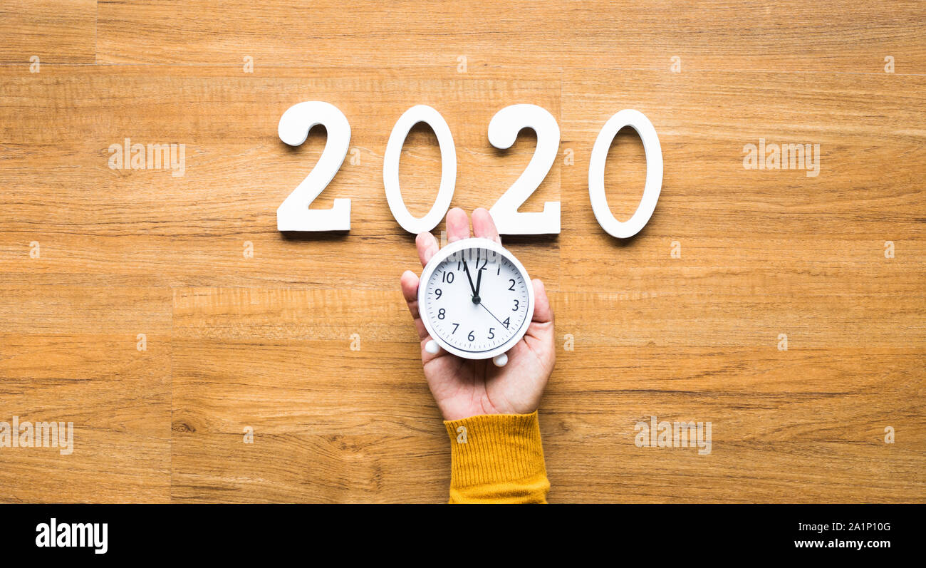 2020 celebration countdown with hand holding alarm clock and mock up ...