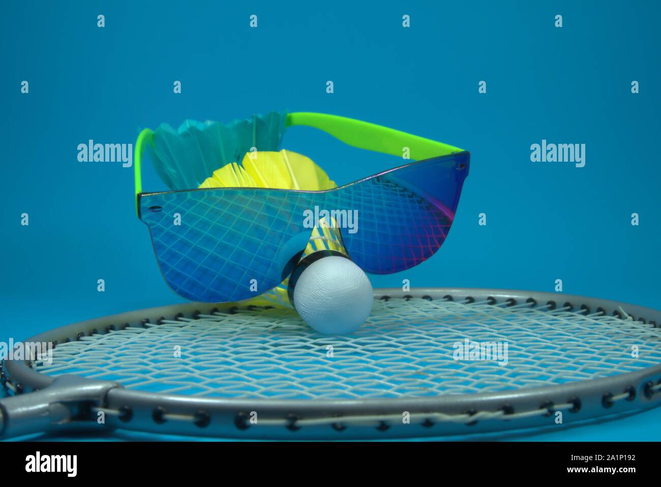 Colorful feathered badminton shuttlecock with sunglasses resting on a ...