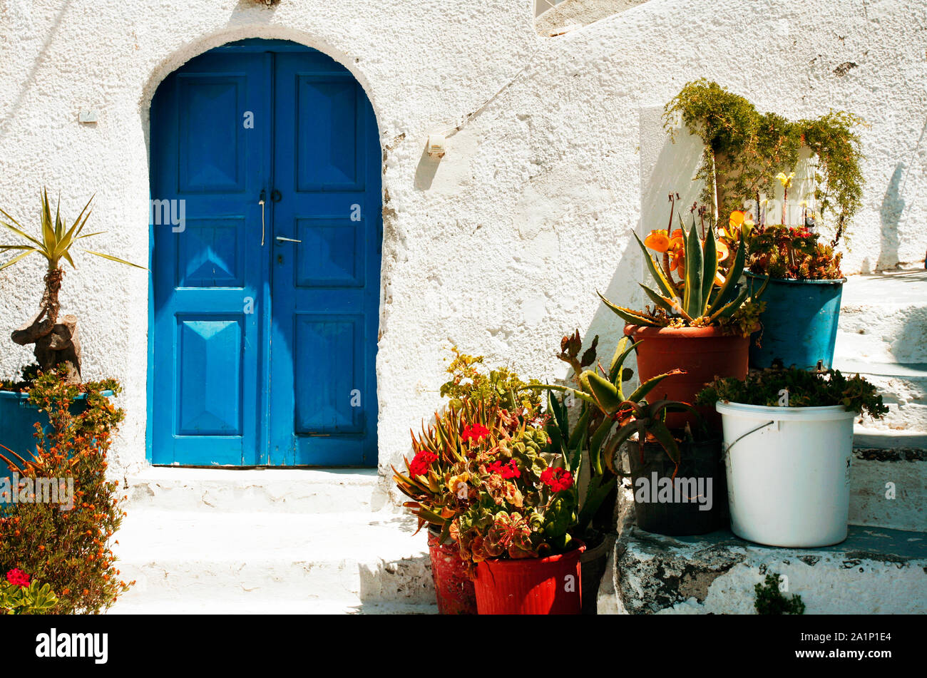 The entrance to a traditional greek house with blue gates and a ...