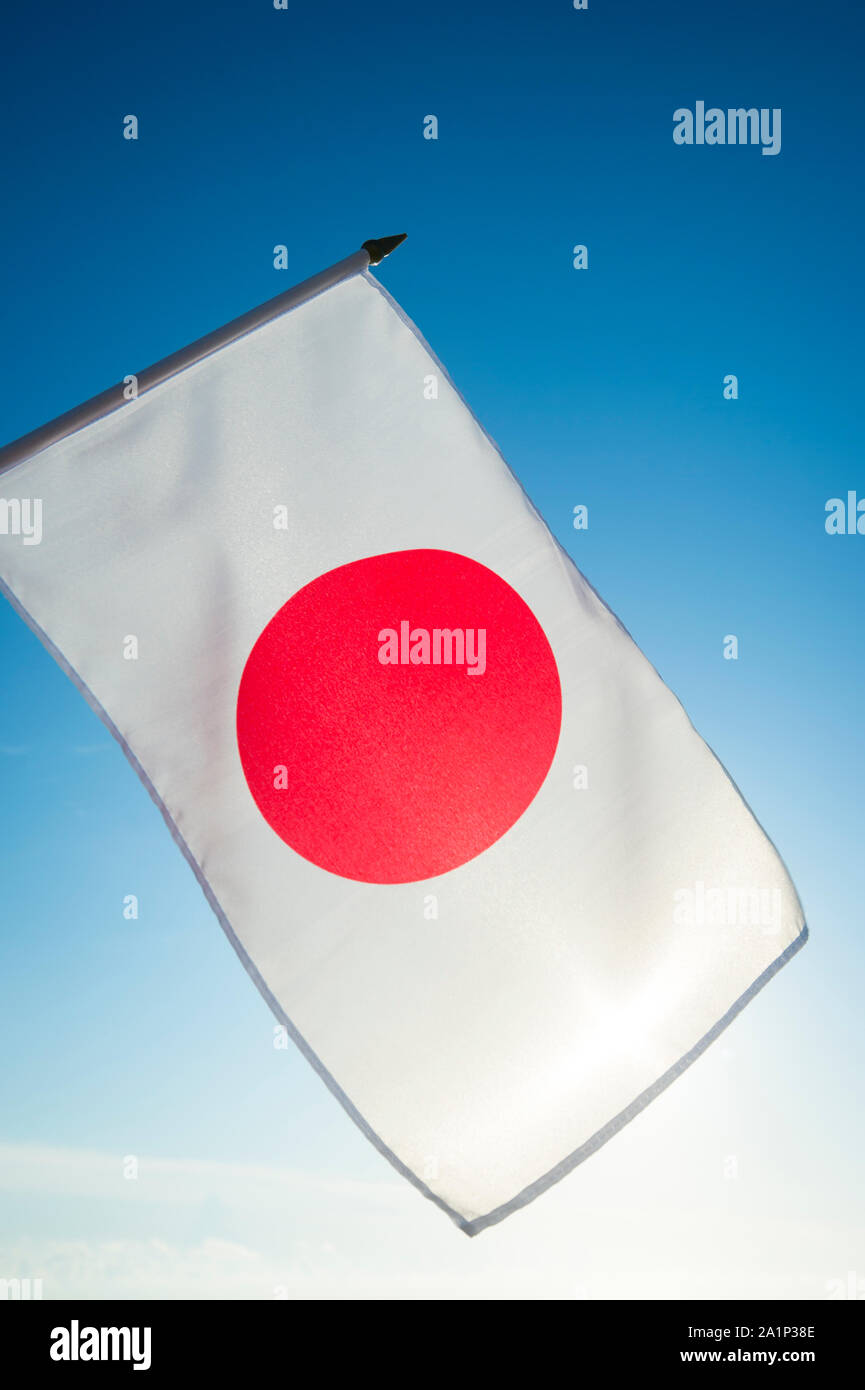 Japanese flag hanging backlit in front of bright blue sky Stock Photo ...