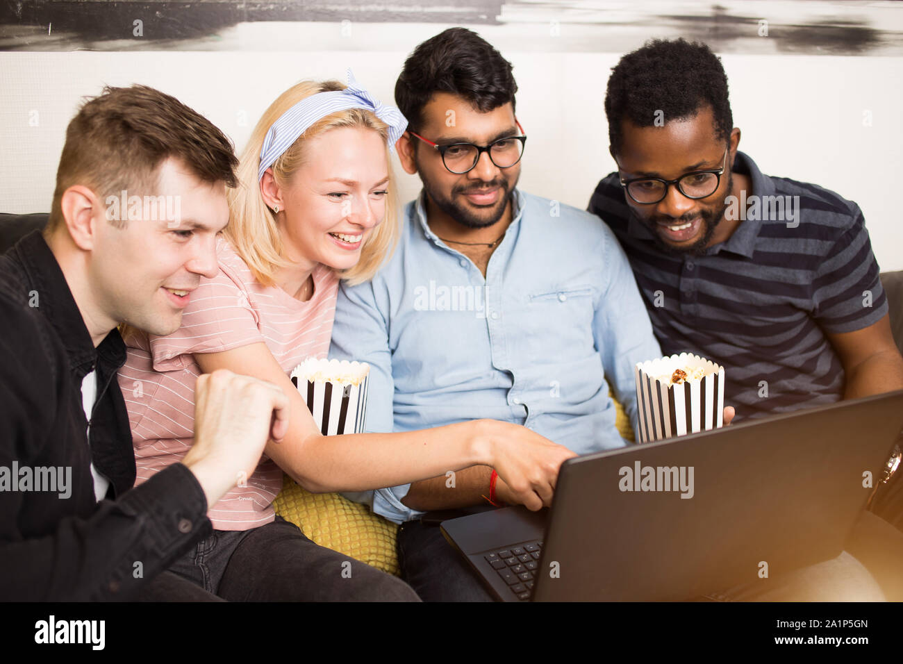 Positive young multi ethnic students watching video on laptop computer ...