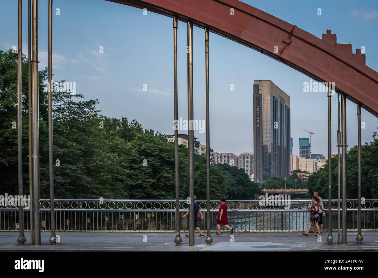 Chengdu, China - July 2019 : People walking across the arched steel ...