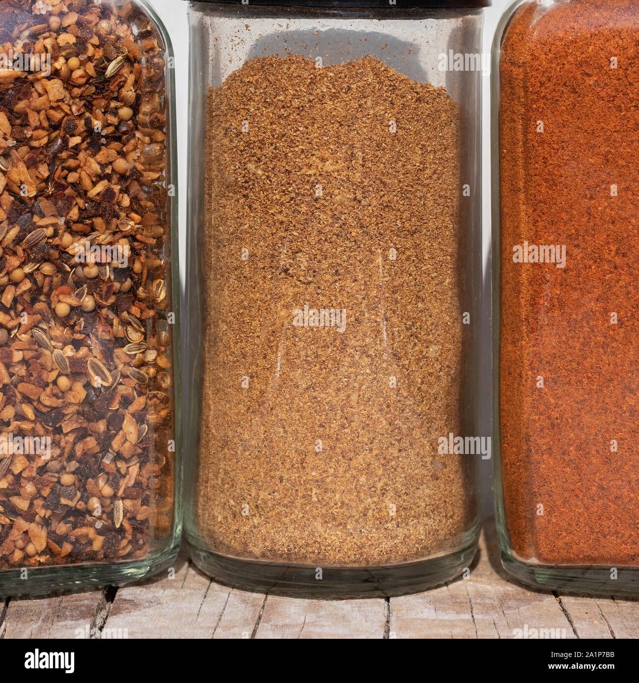 Three jars with spices of different grinding on a white background ...