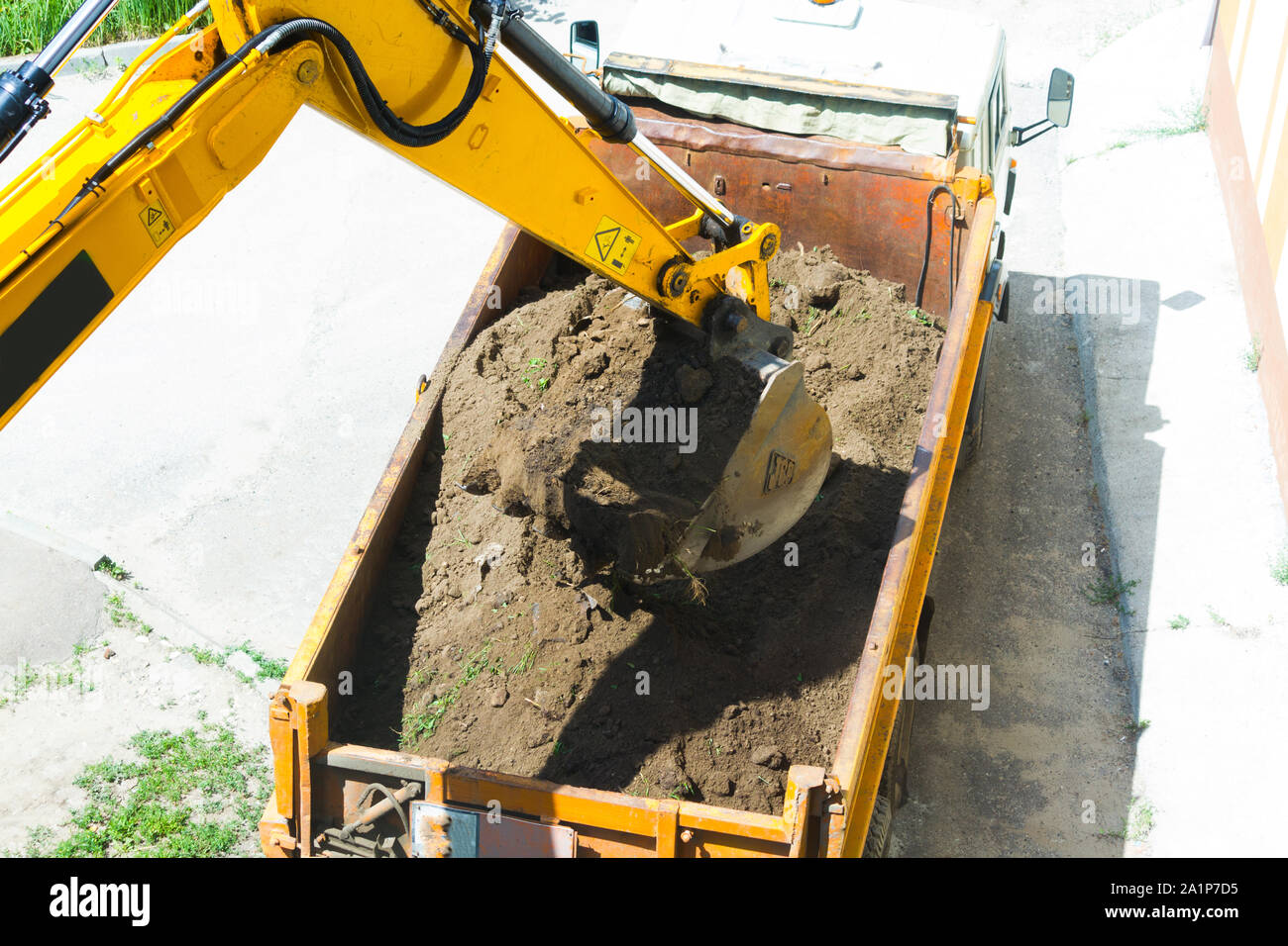 Excavator is loading excavation to the truck. Close up Stock Photo - Alamy