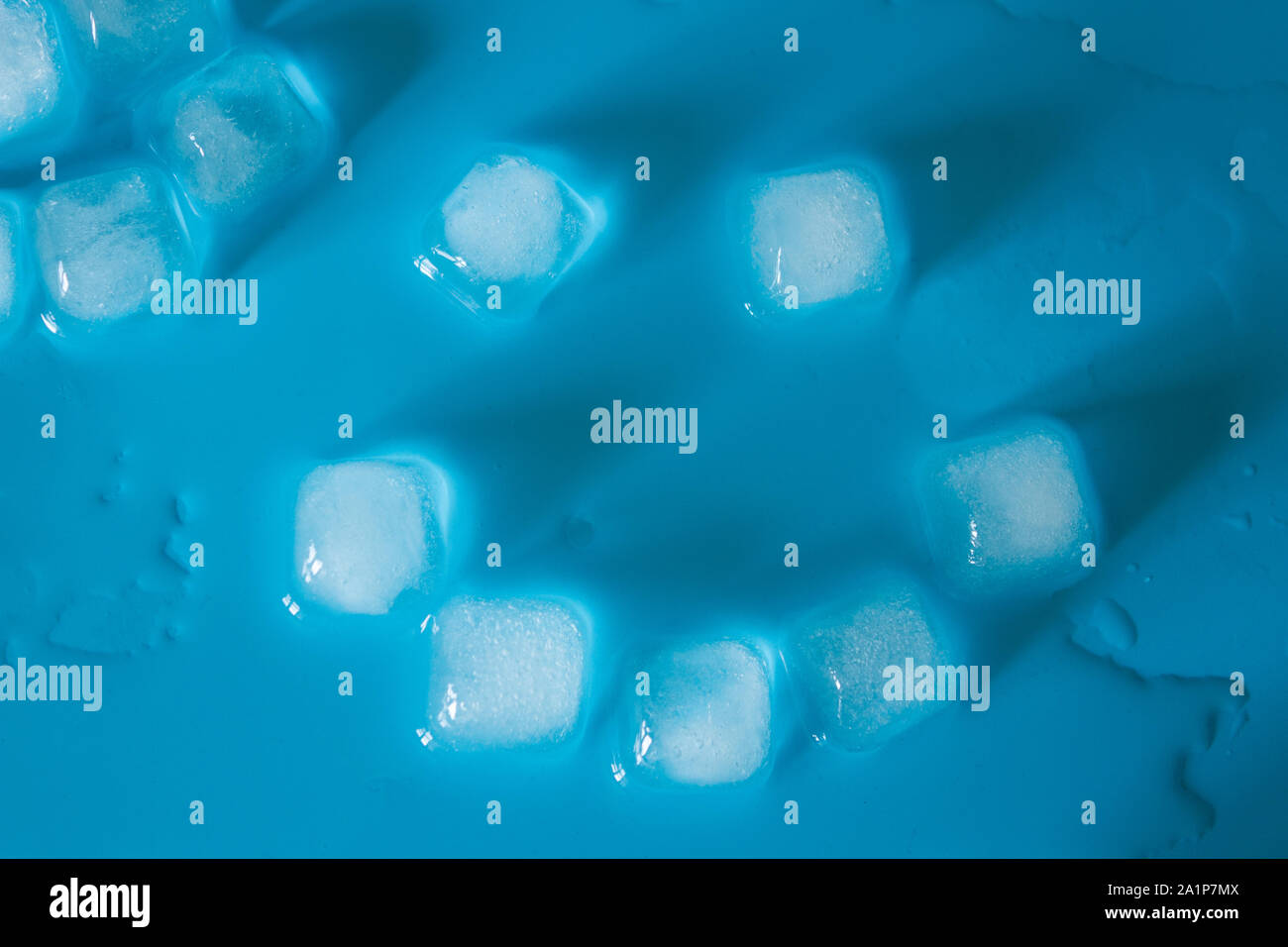 Melting ice cubes background on blue background Stock Photo - Alamy