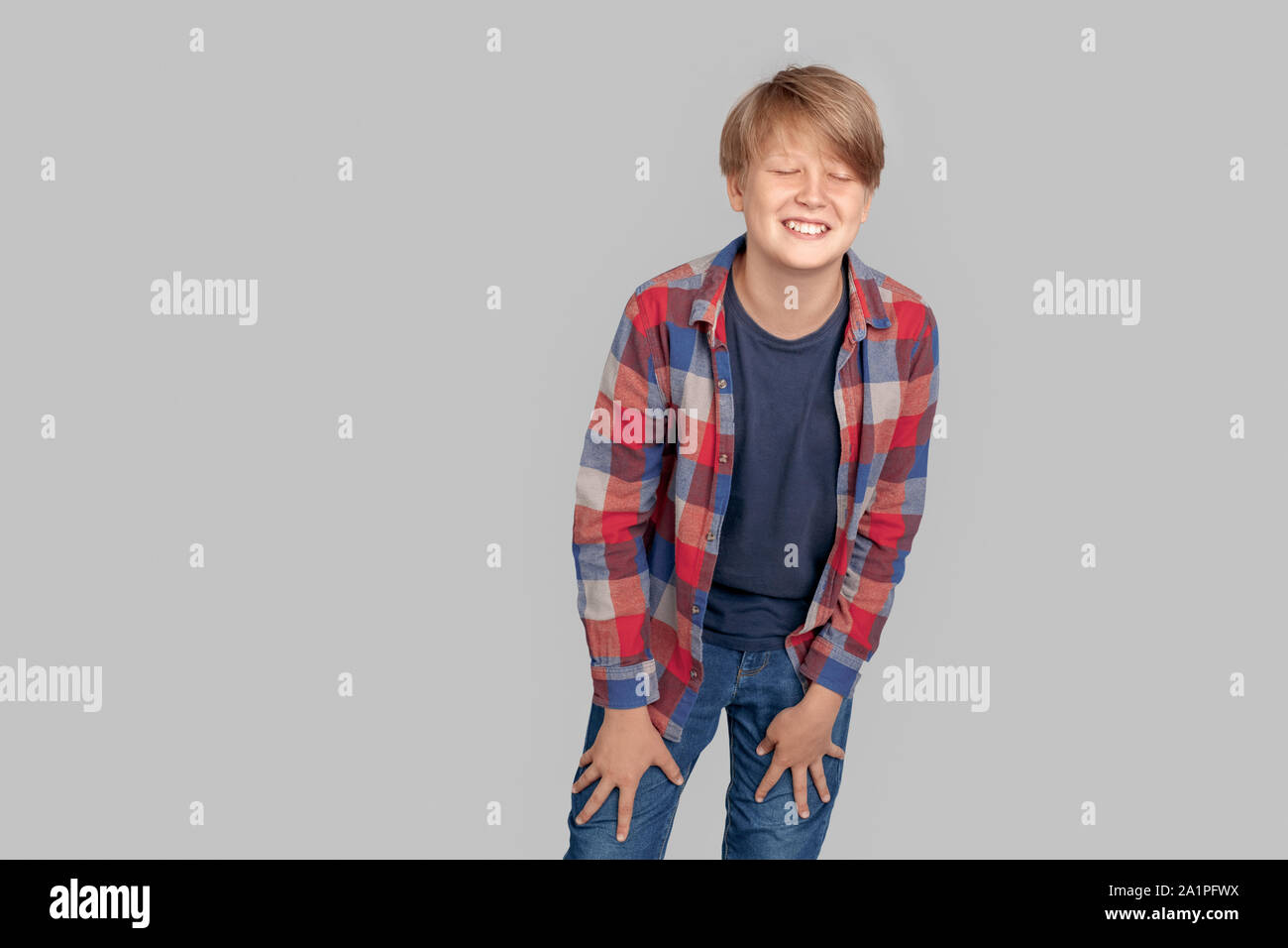 Young boy standing isolated on grey backgroud closed eyes smiling ...