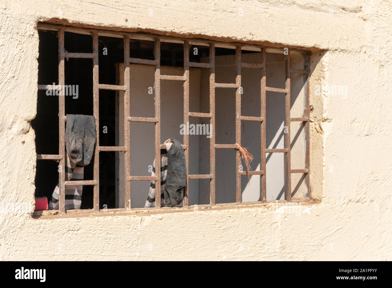 A close uop view of security bars covering a window in a outside room ...