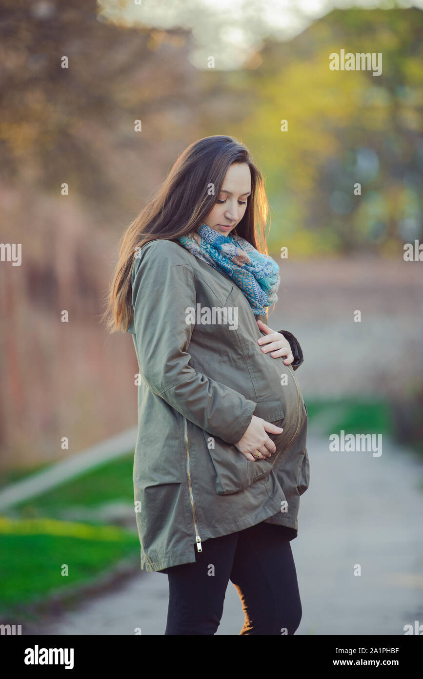 Pregnant woman sticks behind belly. Happy pregnancy time Stock Photo ...