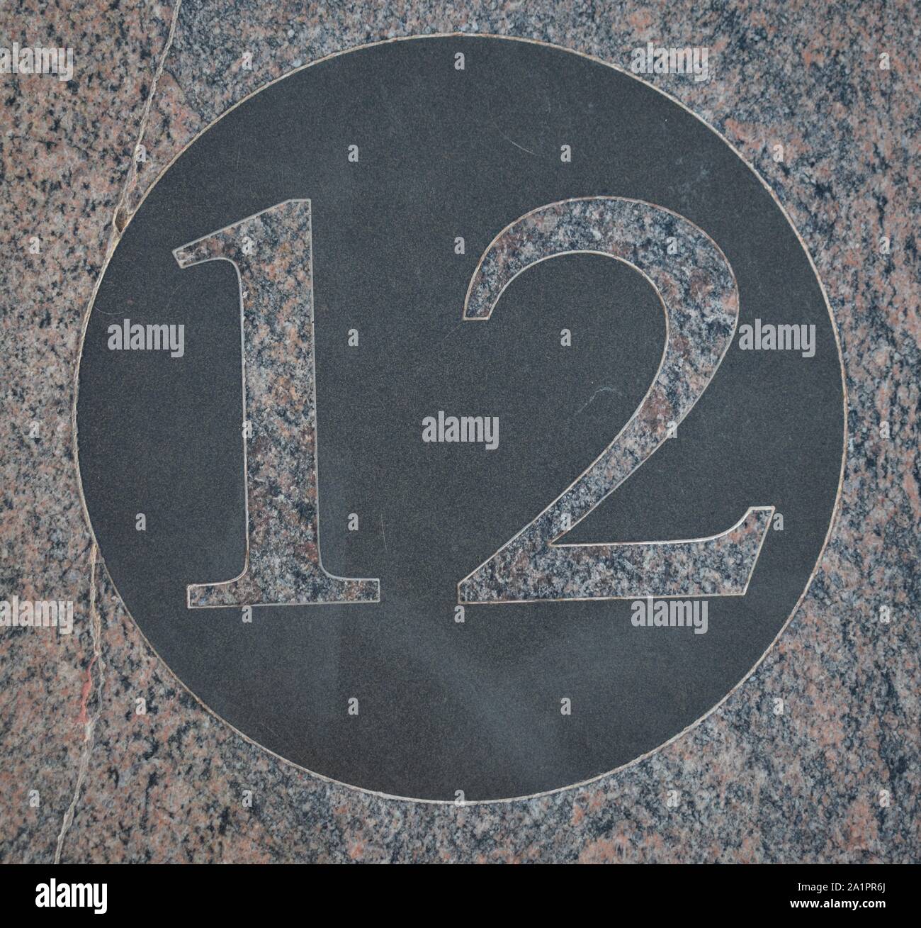 Number twelve black circle on pink marble Stock Photo - Alamy