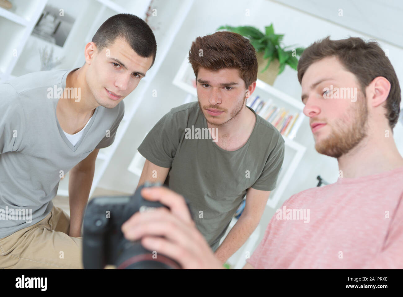 young men checking photos in camera Stock Photo - Alamy