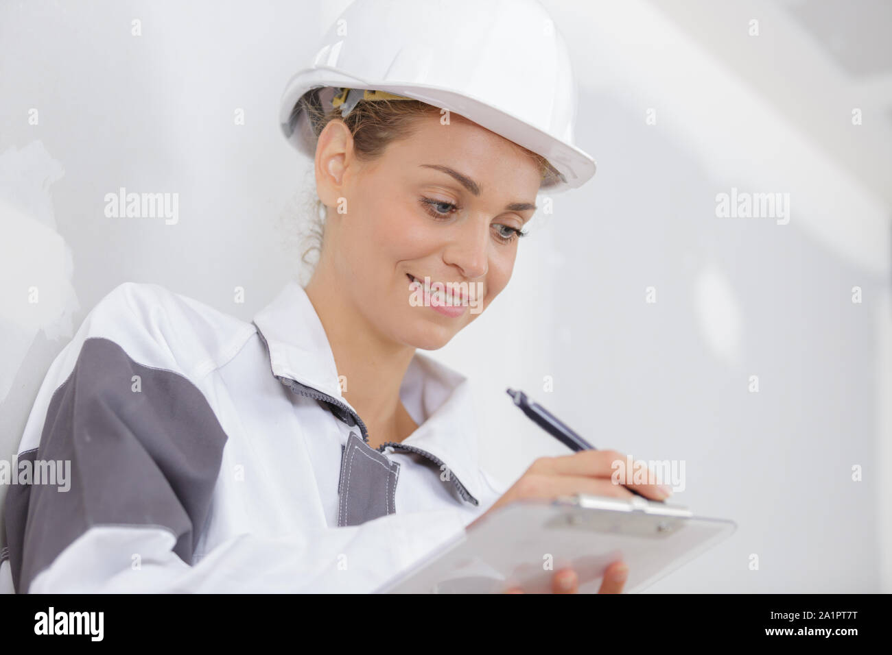 female builder writing on a clipboard Stock Photo - Alamy