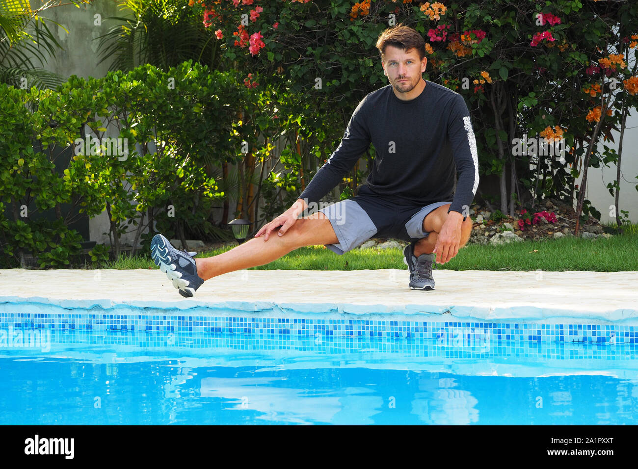 man doing stretching exercise by the swimming pool Stock Photo - Alamy