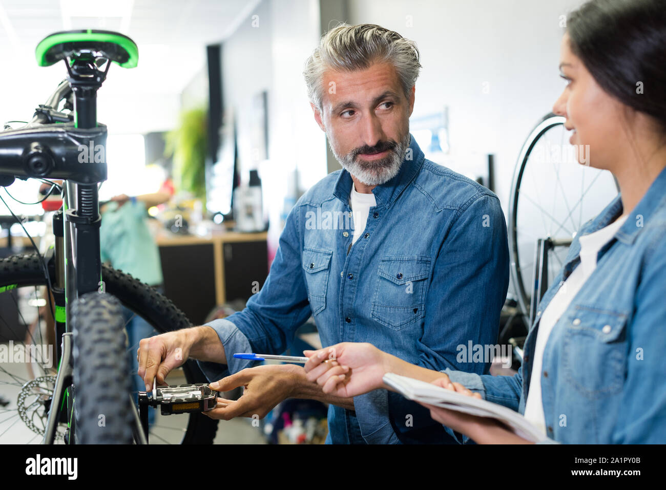 female and male workers fixing a bike Stock Photo - Alamy