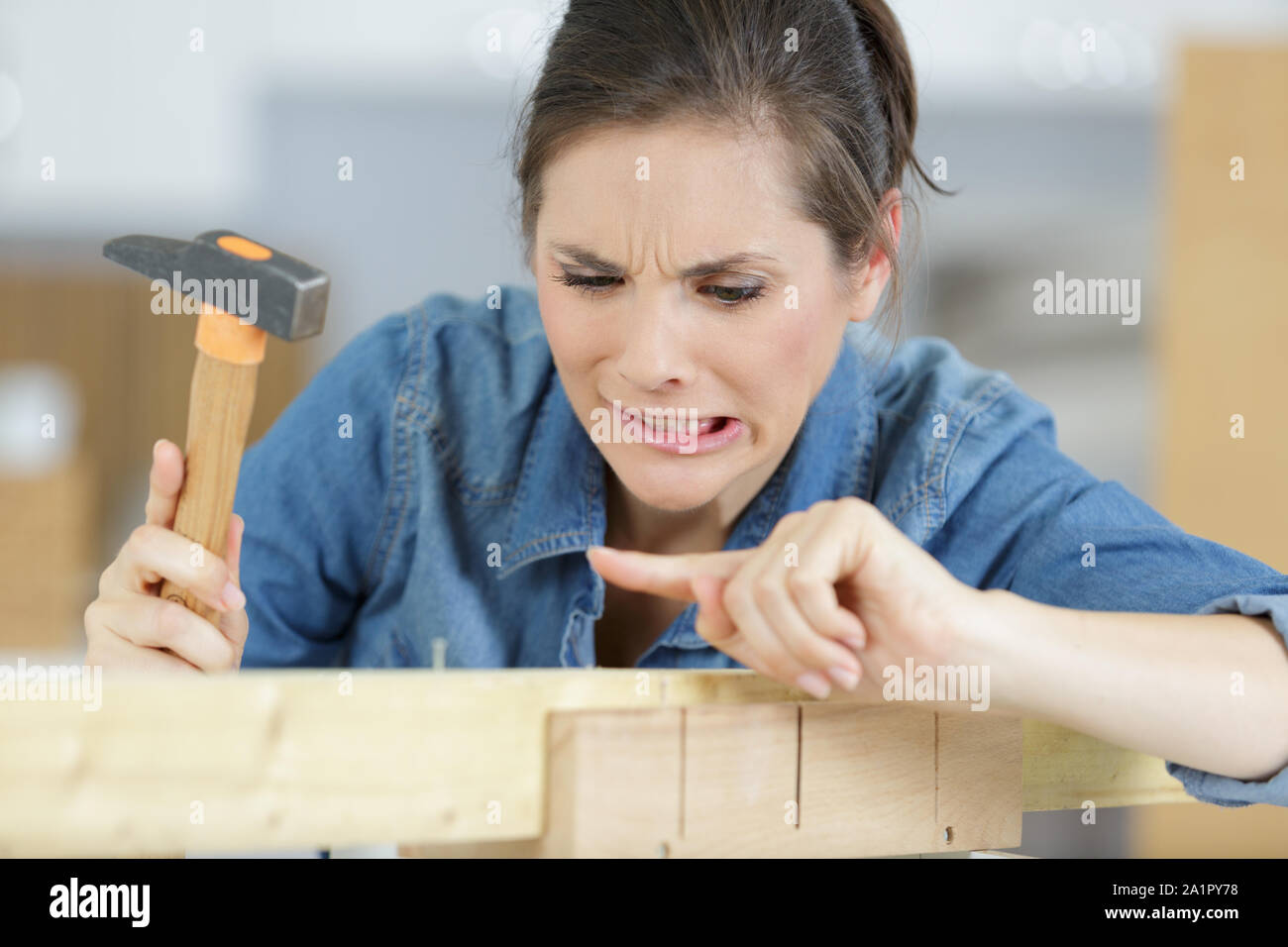 photo of young woman hit with a hammer on finger Stock Photo - Alamy