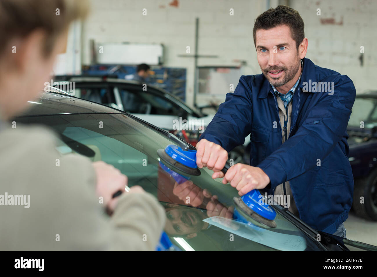 mechanics using suction pads on car windscreen Stock Photo - Alamy