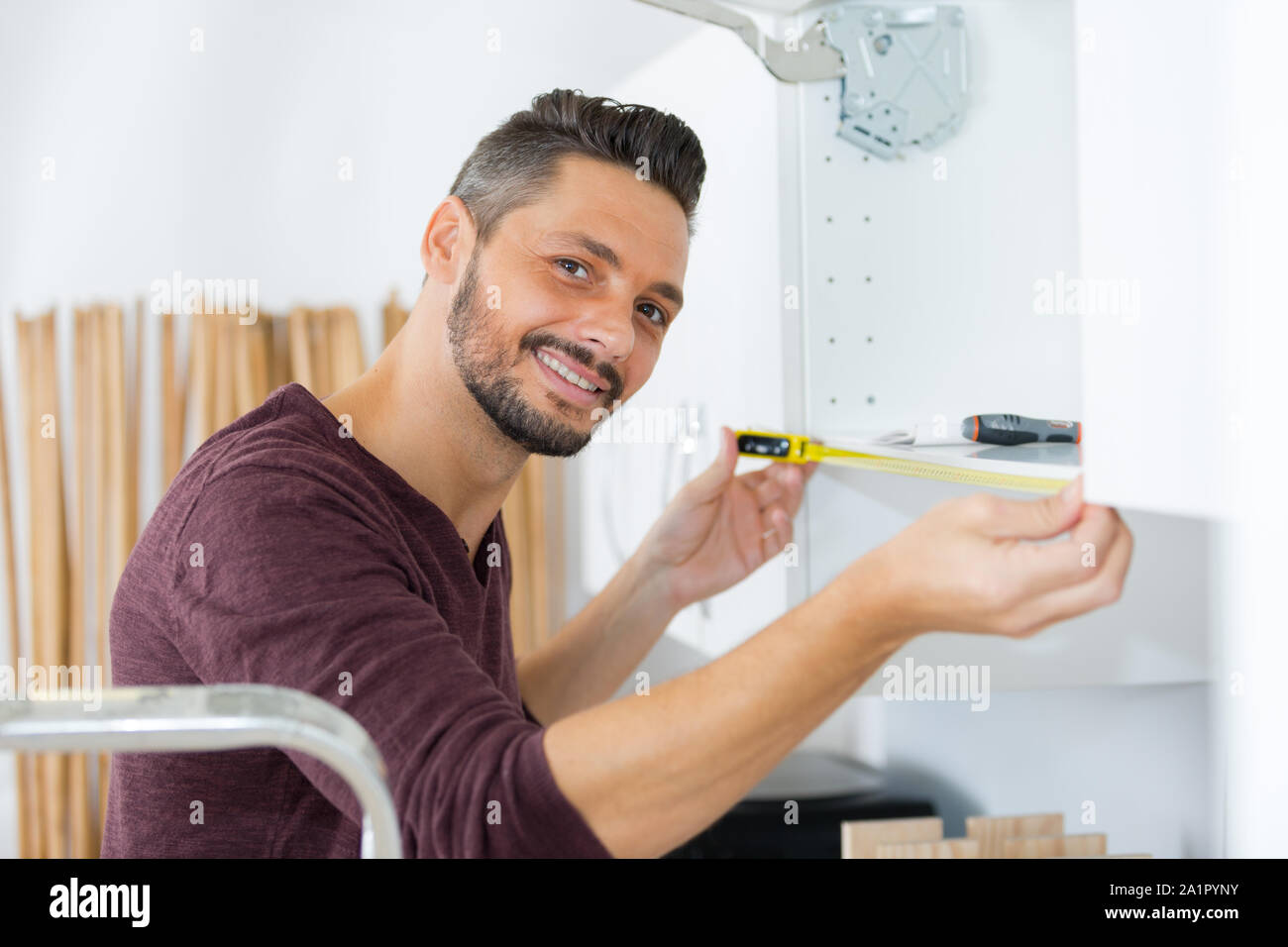 man measuring cabinet Stock Photo - Alamy
