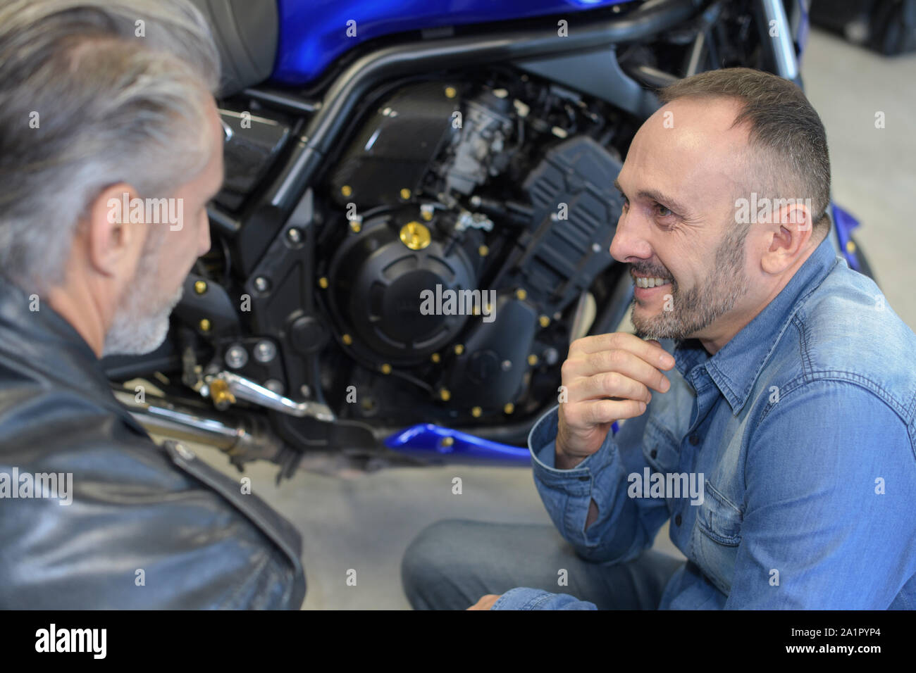 happy male mechanic with his client in garage Stock Photo - Alamy