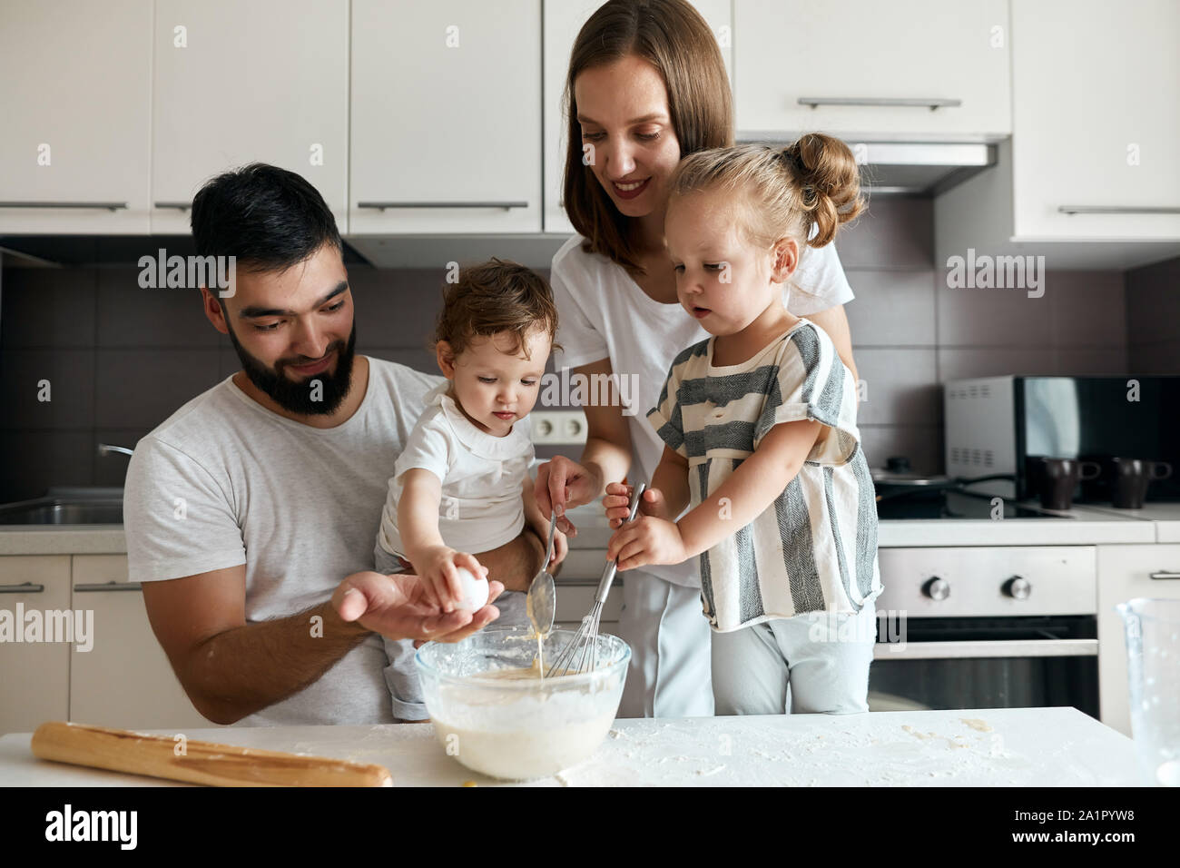 kids and parents partisipating in cooking process.family trying new ...