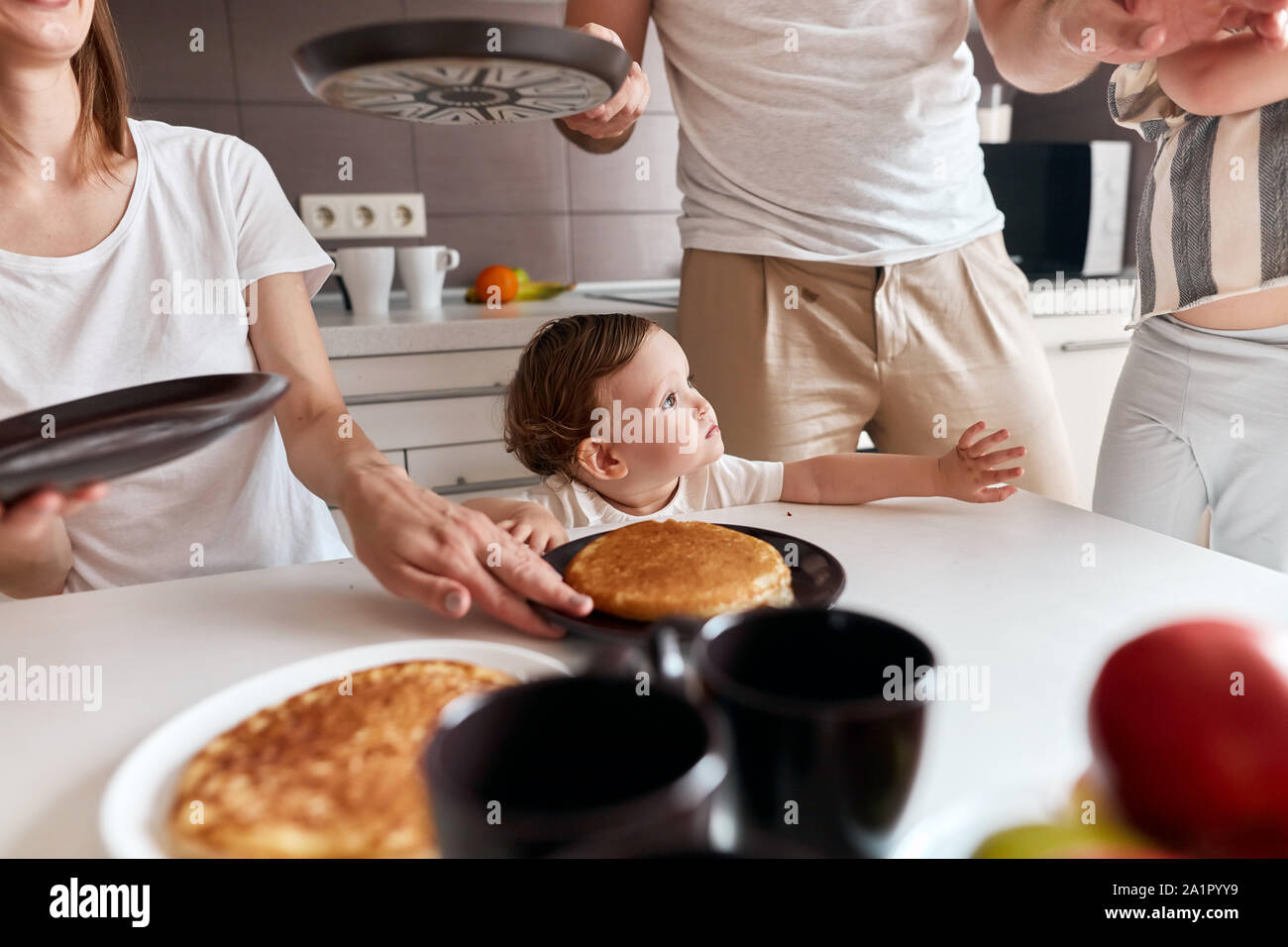 cute little girl waiting for breakfast, kid is looking at her elder ...