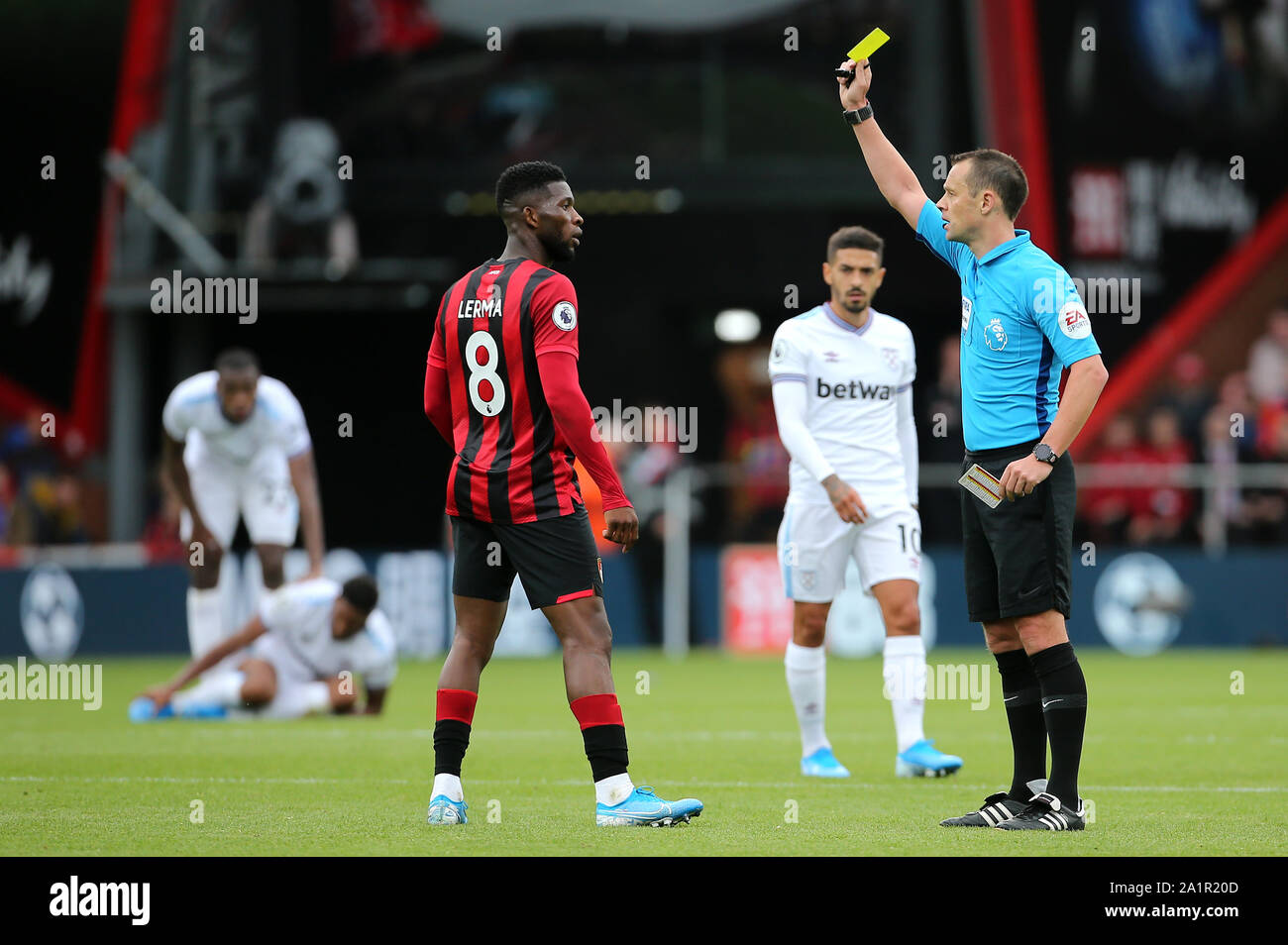 Match referee Stuart Attwell shows a yellow card to Bournemouth's ...