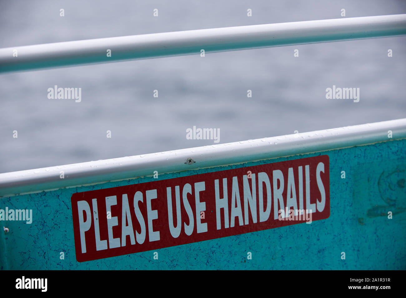 Large red sign with the warning "Please use handrails" on the side of ...