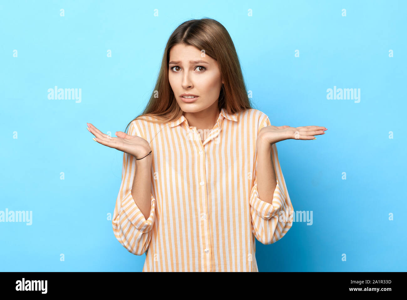 unsure puzzled young woman spreads palms in bewilderment, girl has ...