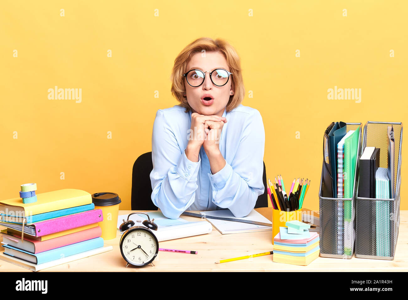 emotional secretary with wide open mouth , looking at the camera with ...