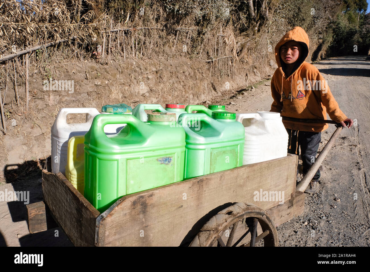 Boys push a cart full of water containers in the Khasi Hills, Meghalaya ...