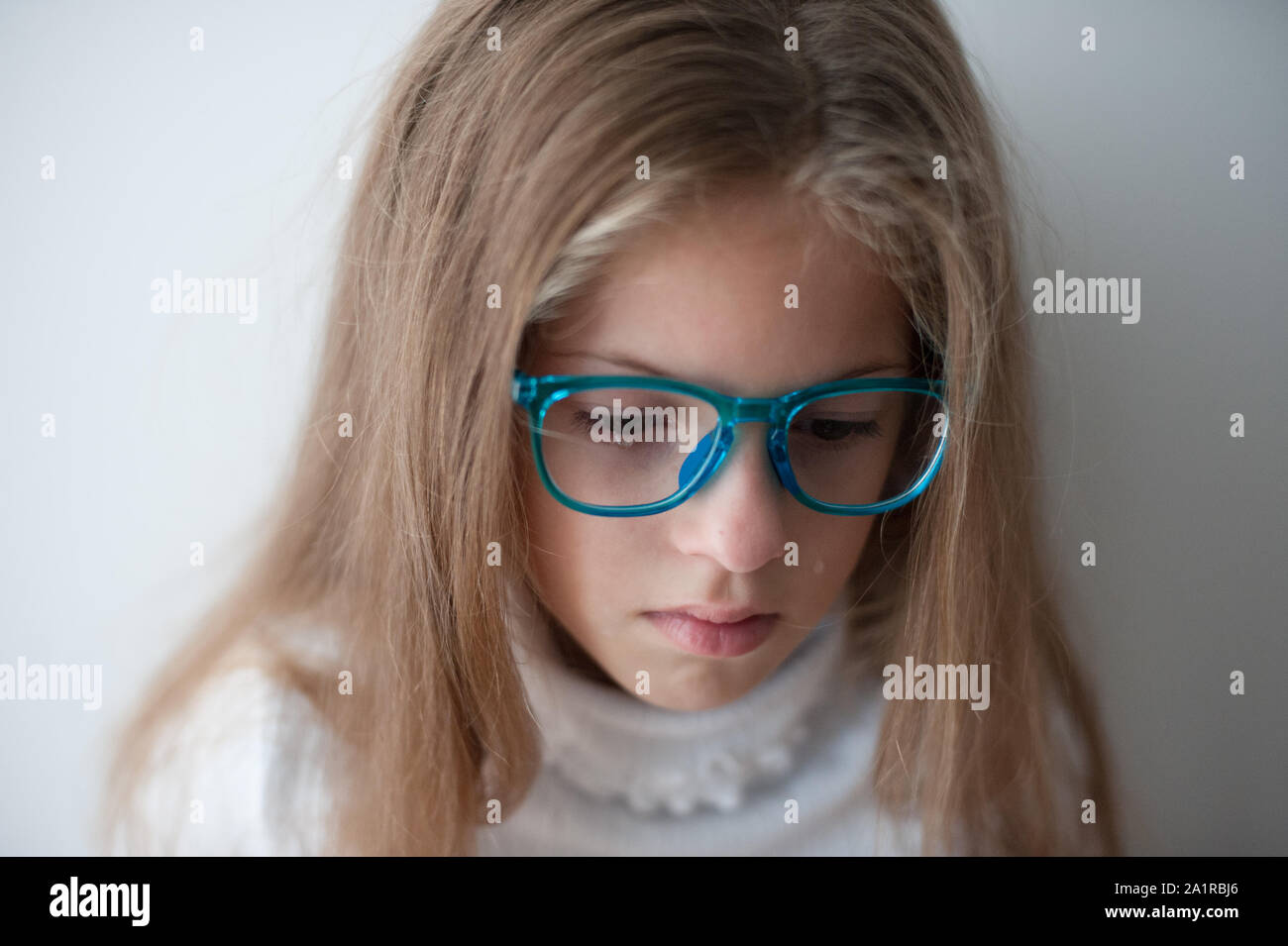 beautiful caucasian little girl in blue glasses crying with bitter tear ...